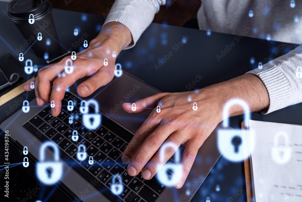 A programmer is typing a code on a keyboard to protect a cyber security from hacker attacks and ...