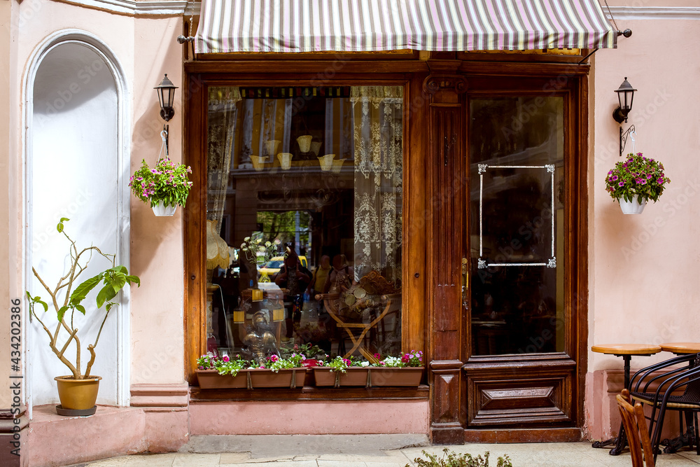 facade of a retro cafe with a large window and a wooden door with glass ...