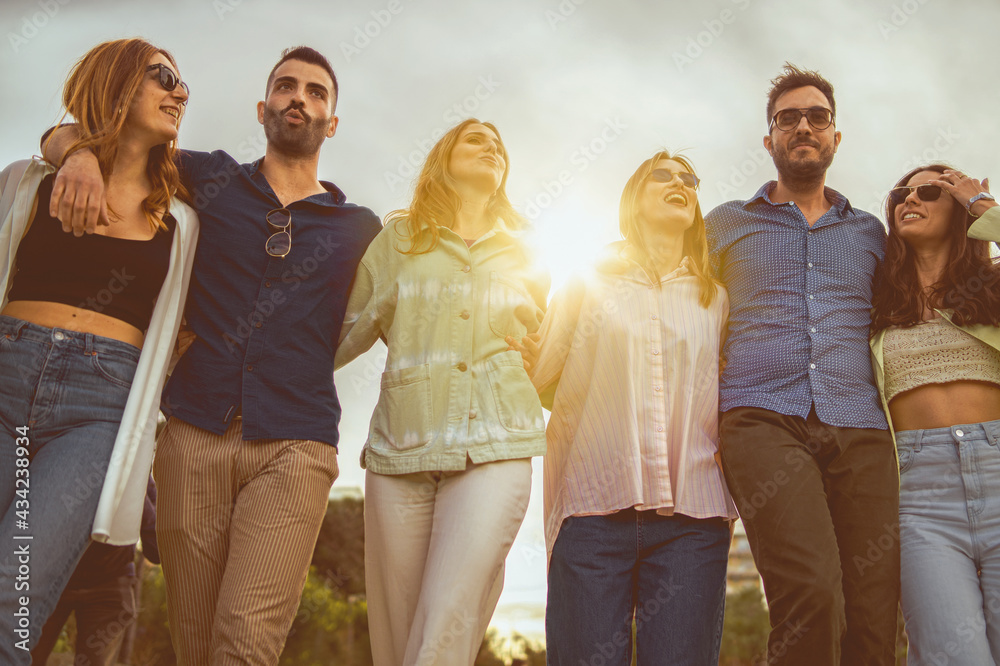 Group of young smiling best friends hugging each other with their arms ...