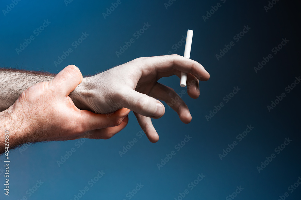 Pale crooked male hand, close-up, holding a cigarette. Healthy hand ...