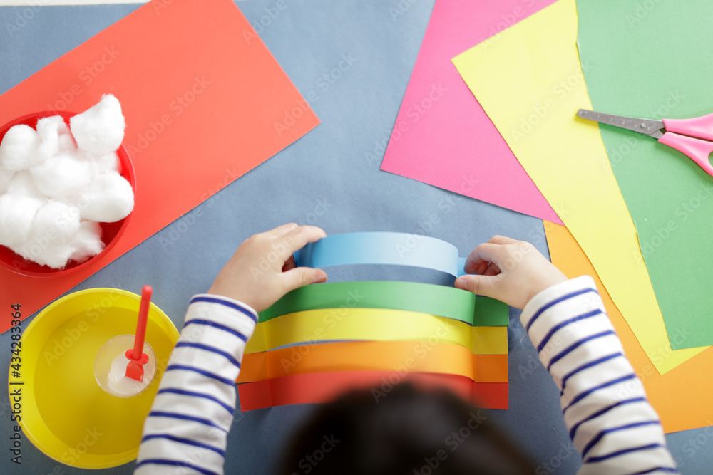 young girl making paper rainbow craft for homeschooling Stock Photo ...