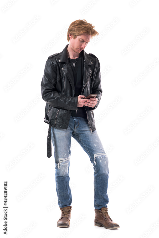 Cool stylish rocker male using phone wearing leather jacket and torn ...