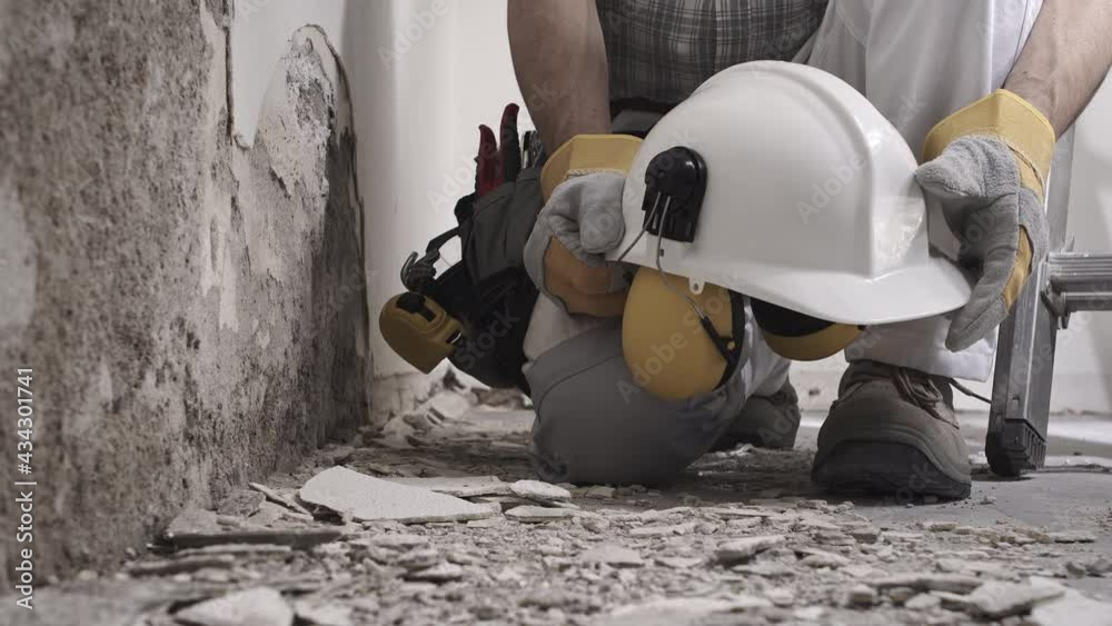 house renovation concept, construction worker holds in hands helmet and ...