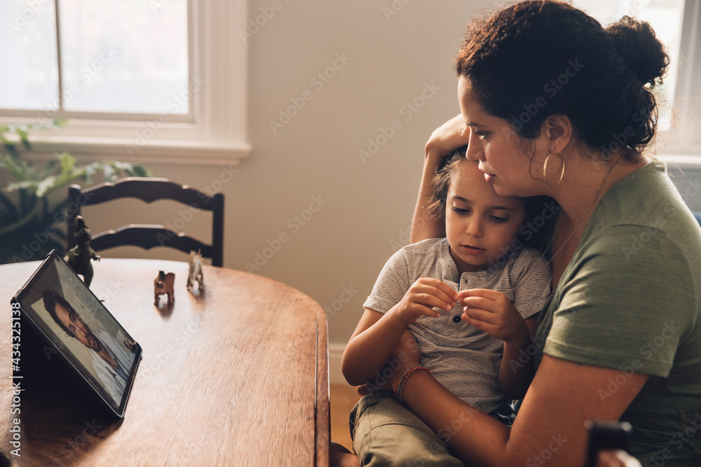 Mother taking online consultation from a doctor on her son sickness ...