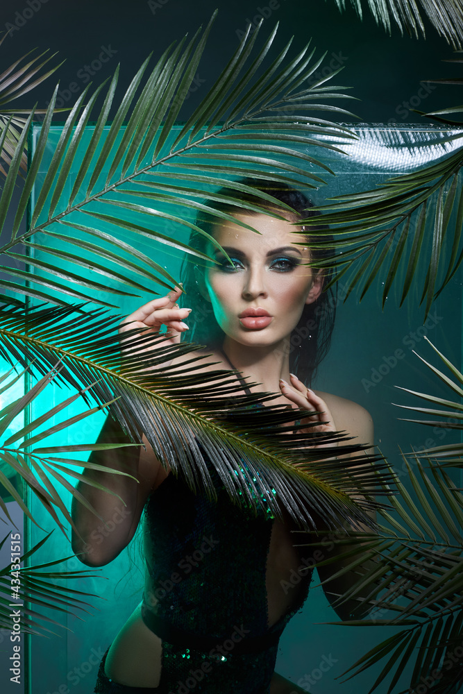 Beauty woman in palm leaves wet makeup, tropical portrait girl in green ...