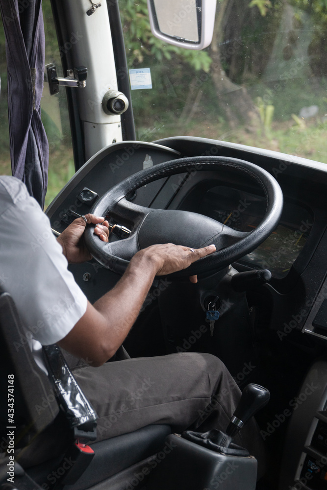 Close-up of a driver's hands holding the steering wheel of a modern bus ...