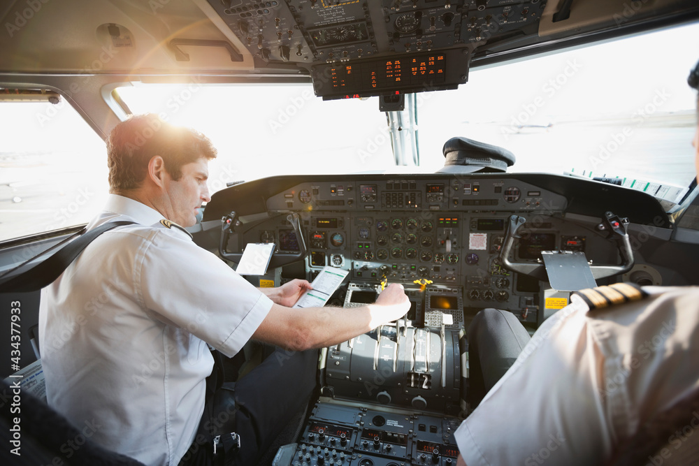 Pilot and copilot checking control panel in airplane cockpit ภาพถ่าย ...