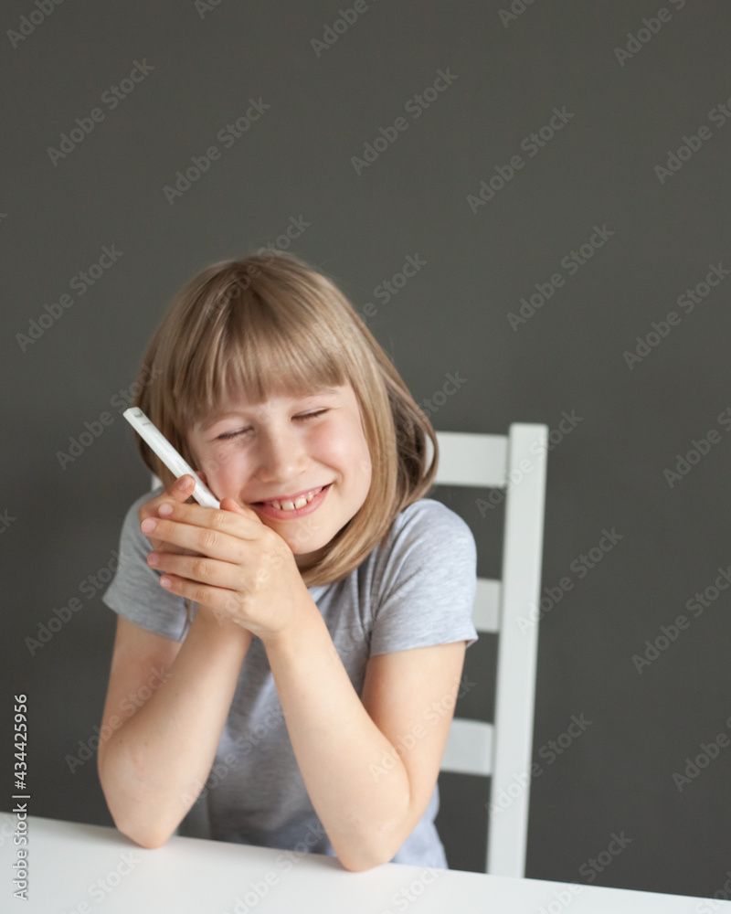 A little blond girl using covid-19 swab test. Schoolgirl sitting, self ...