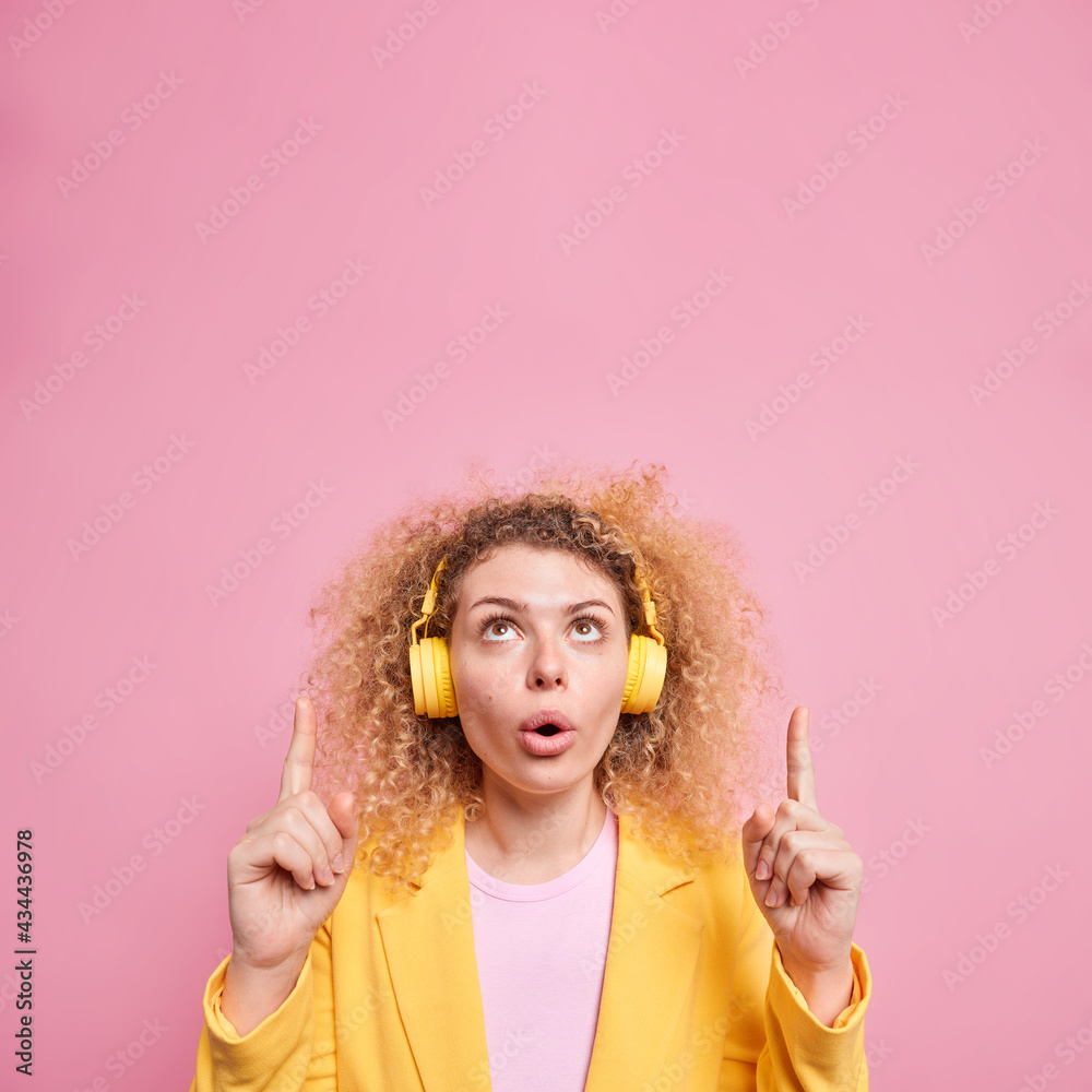Vertical shot of speechless curly haired woman with astonished ...