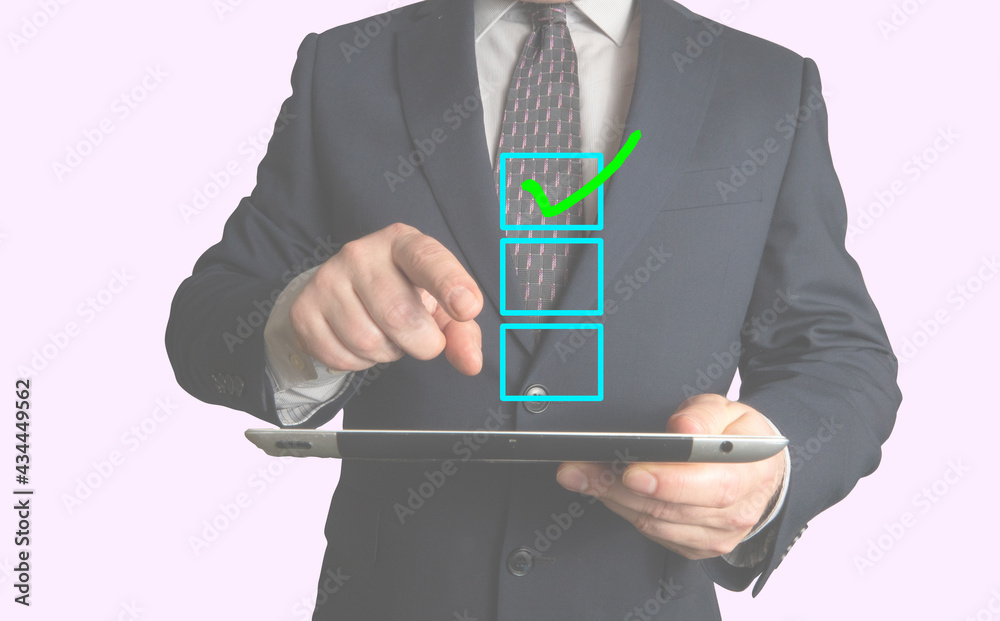 Businessman about to touch a tablet to tick a completed task on a ...
