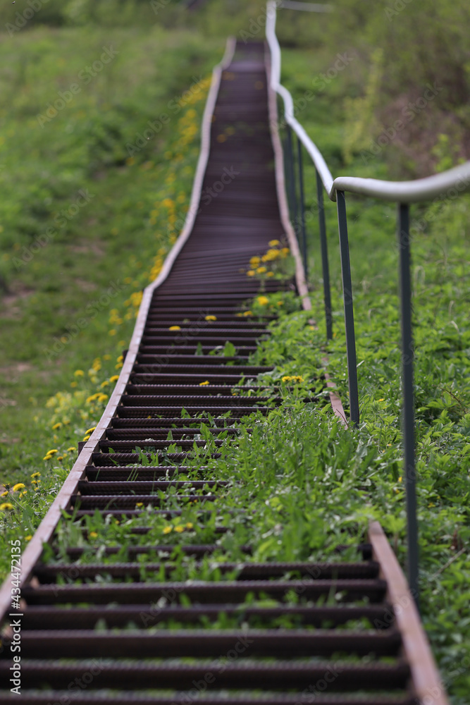 A metal staircase leads up the hill.An old rusty ladder made of metal ...
