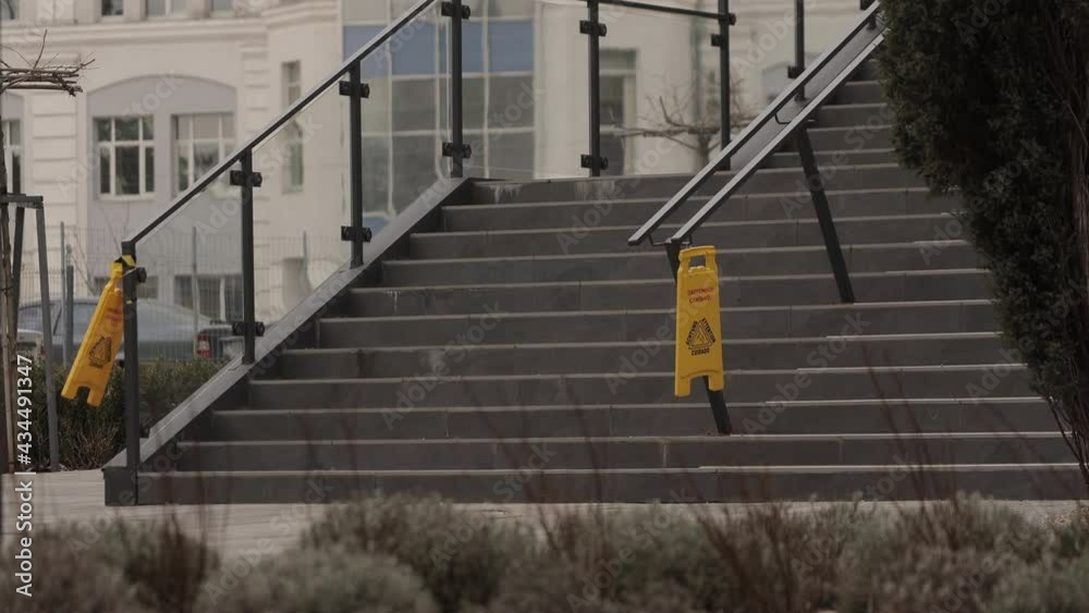 There are yellow signs on the railing that say careful slippery. The ...