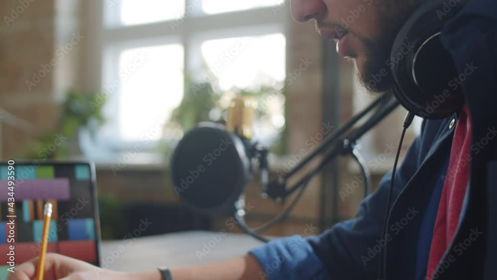 Tilt down close up shot of male podcast presenter with headphones over ...