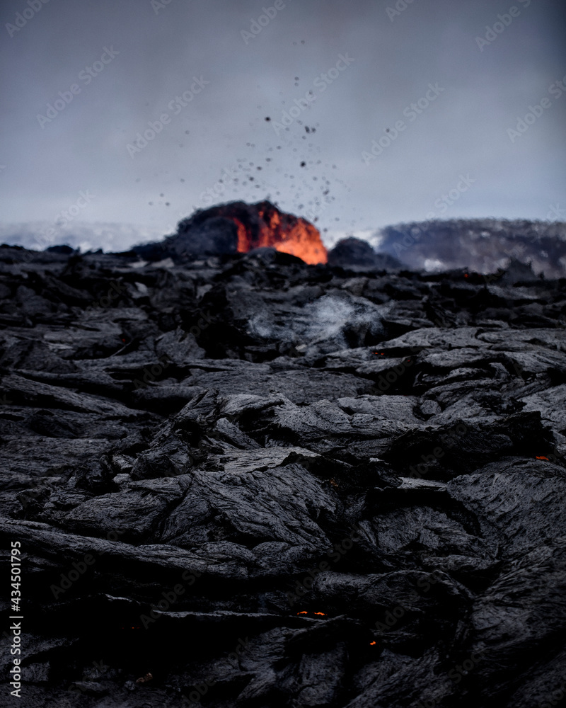 View of a crater and fresh lava flowing from volcano eruption in ...