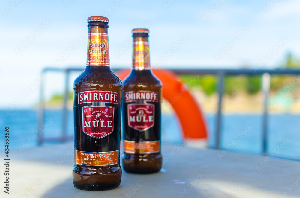 Two cold Smirnoff Mule bottles on a table aboard a yacht, tropical ...