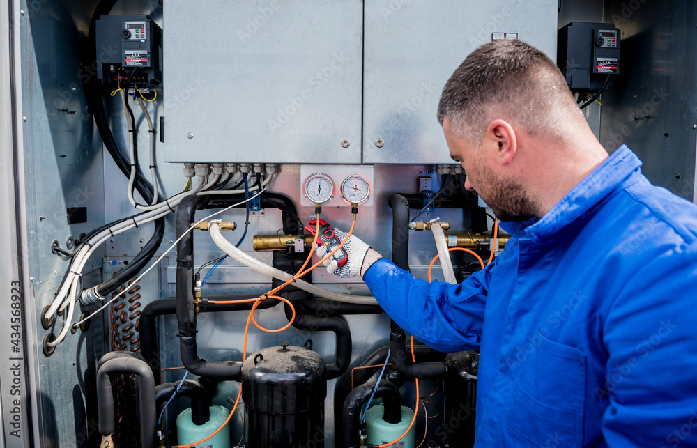 The technician checking power lines of the heat exchanger with current ...