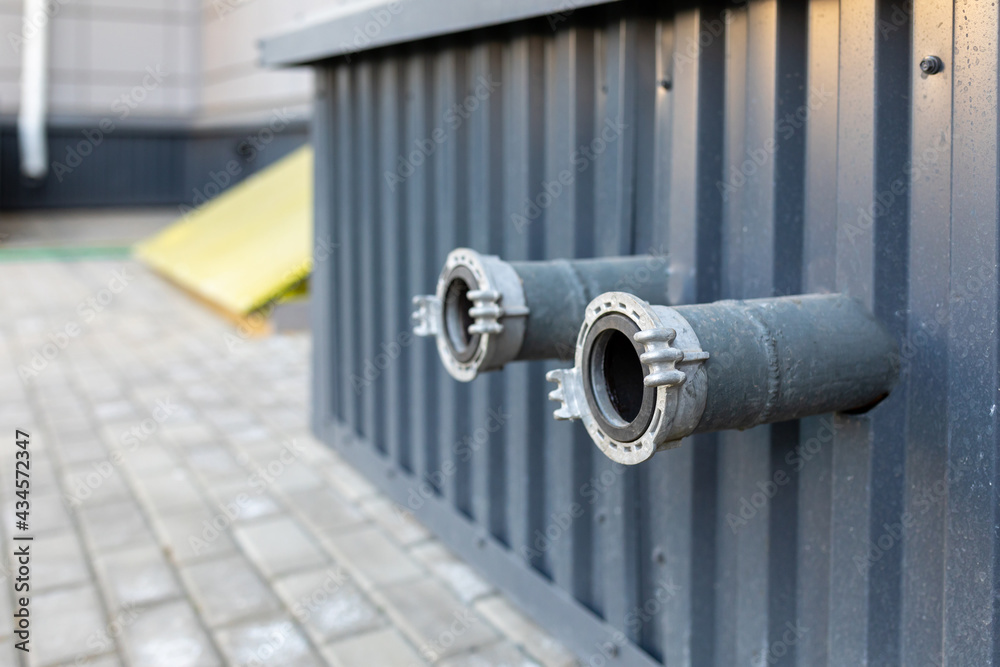 Two sockets for connecting fire hoses on the metal wall of an ...