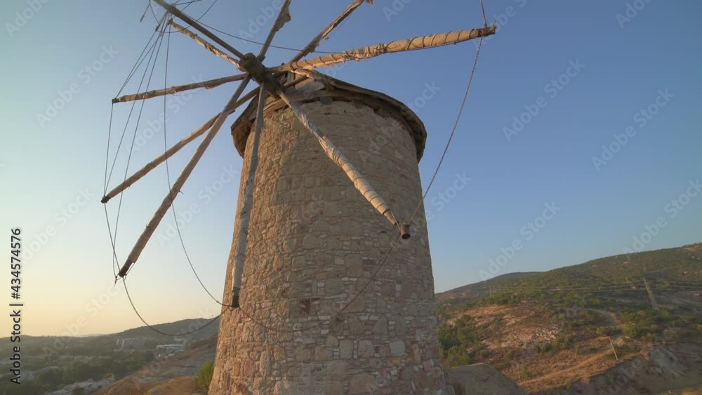 Old traditional historic windmill by the sea at the sunset.Wind power ...