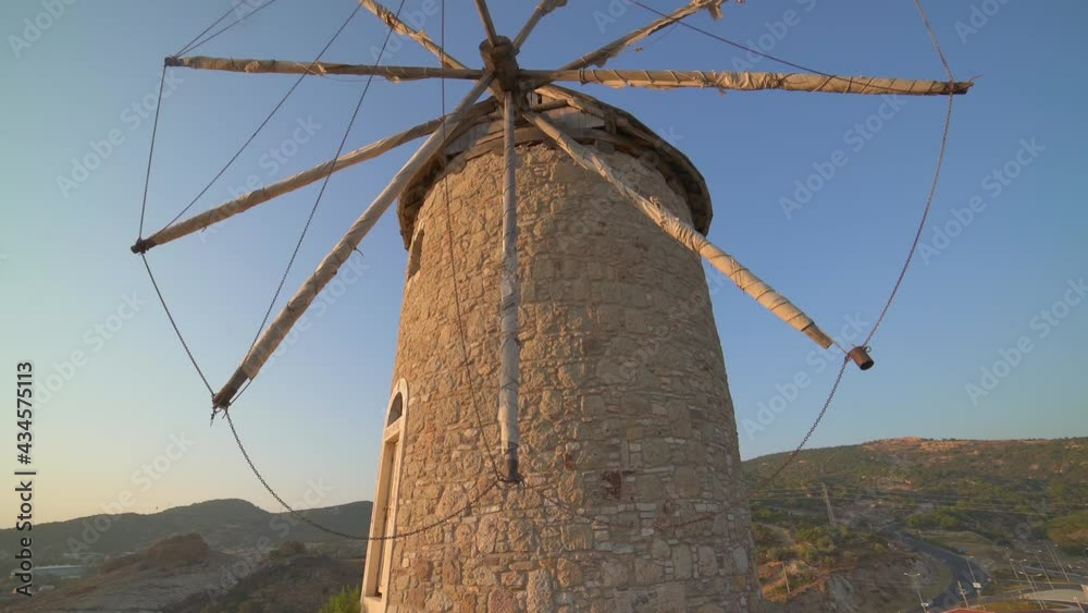 Old traditional historic windmill by the sea at the sunset.Wind power ...