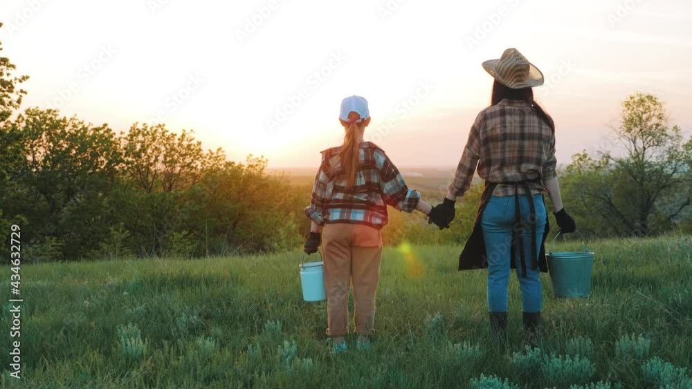 Cows farm concept. Young mother farmer and daughter pour fresh milk. A ...