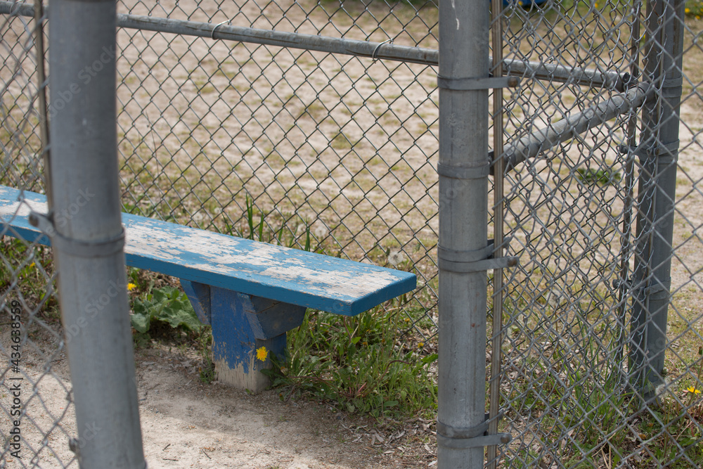 baseball dugout bench (once painted in blue, now weathered and peeling ...