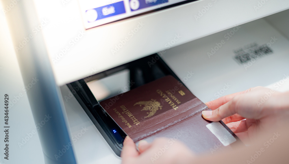 Female hand holding personal passport scanning at the self service ...