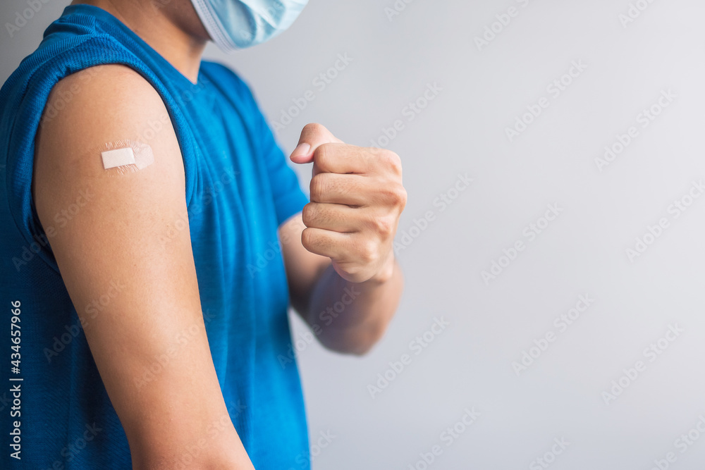 Happy man showing his arm with bandage after receiving vaccine ...