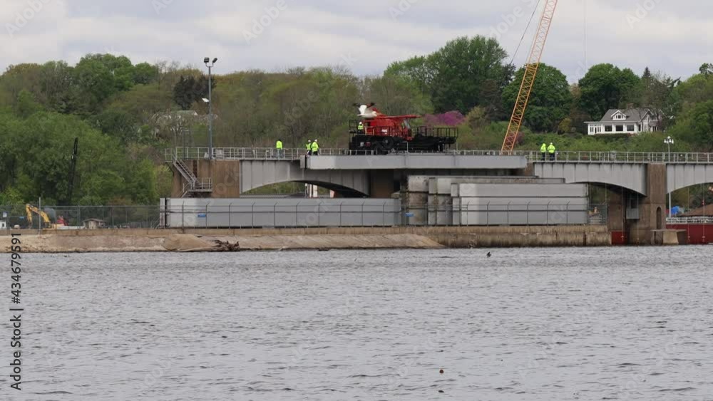 Small Crew of men operating a specialized crane to repair the dam ...