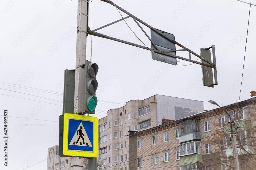Green traffic light and pedestrian crossing sign. Against the ...