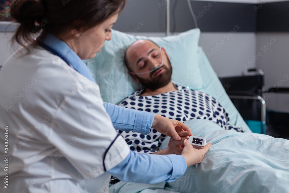 Close up of sick man patient lying in bed with medical oximeter on ...