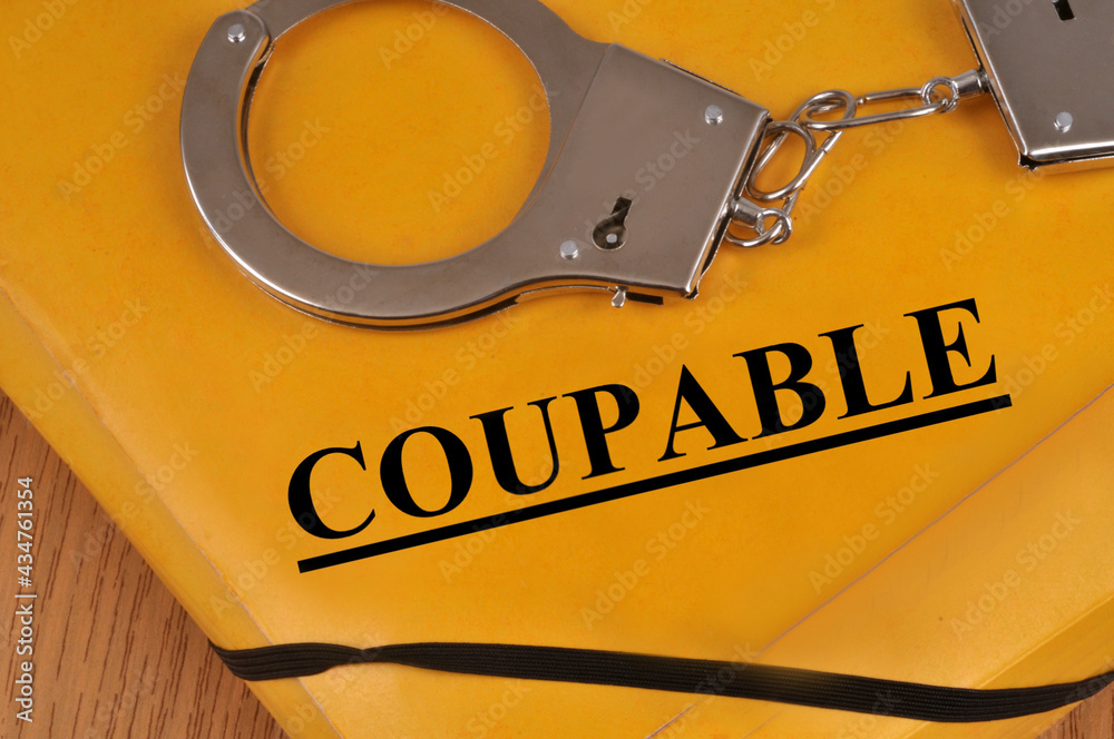 Coupable écrit sur un dossier sur lequel sont posées des menottes Stock ...