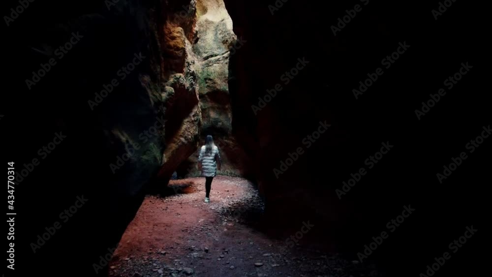 Cave exploration, exploring a cavern. Young woman explorer walks ...
