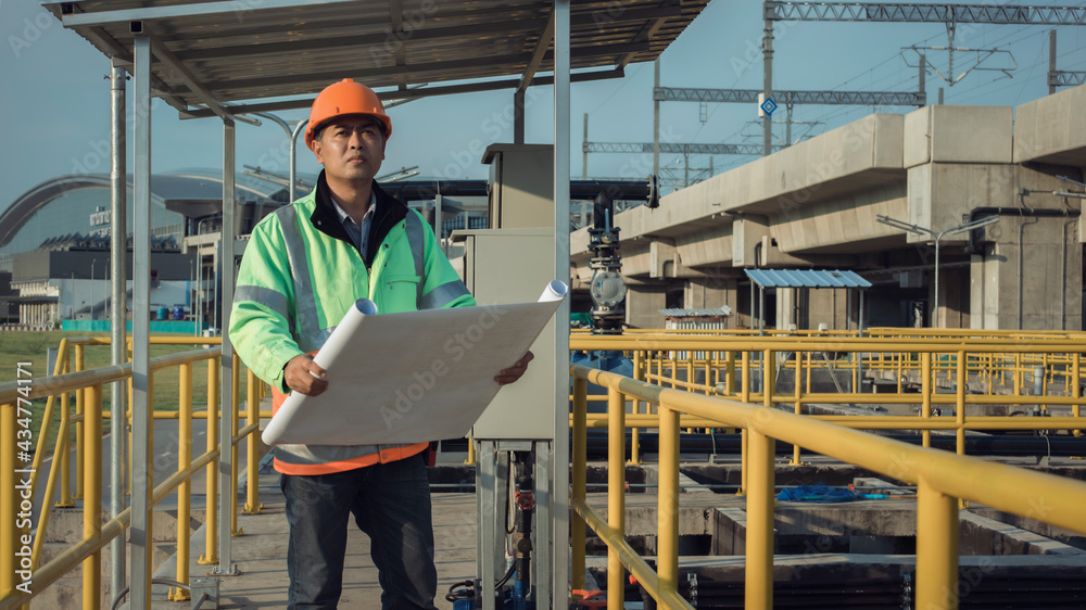 workers holding drawing. Male Industrial Engineers Look at Project ...