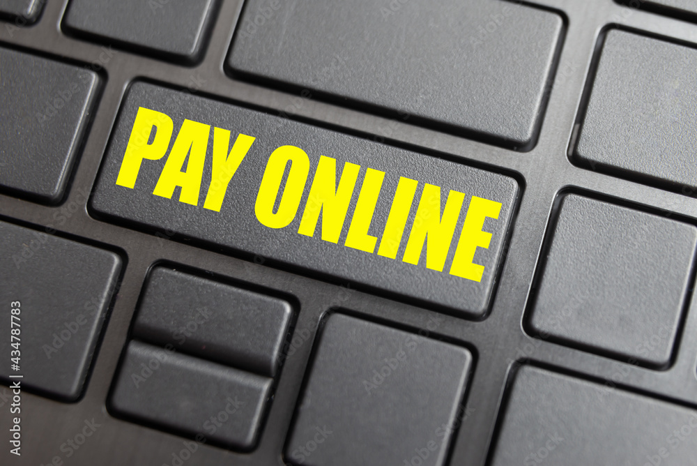Black pc keyboard, with yellow "Pay Online" text. Carrying out online ...