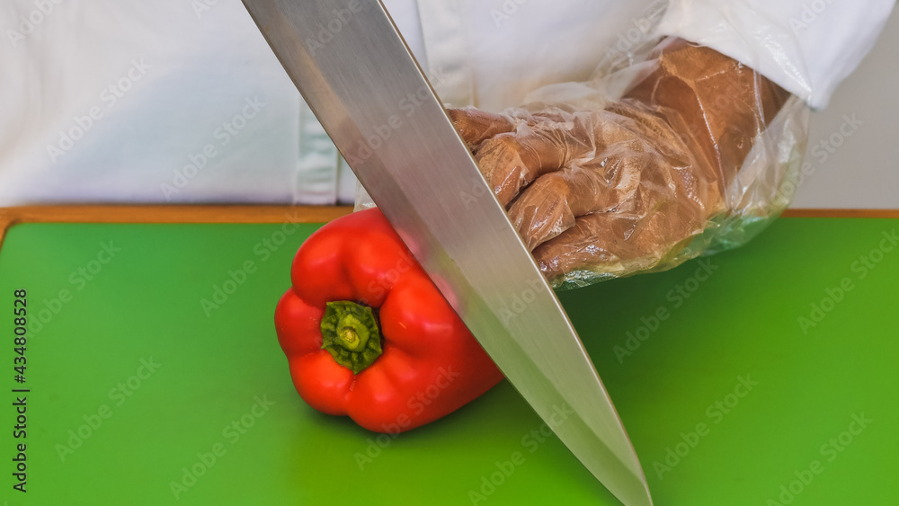 chef cortando una rodaja de chile morrón rojo con el cuchillo para ...