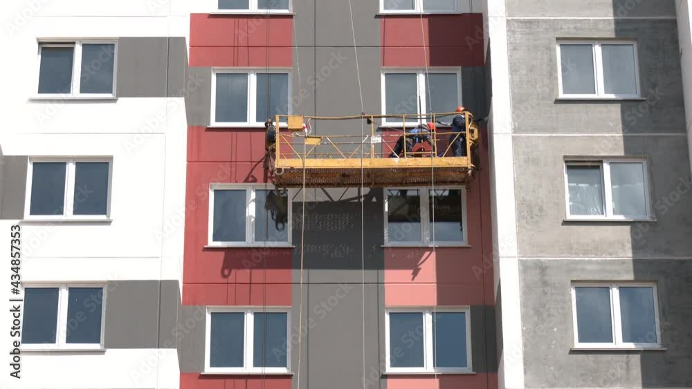 Suspended construction cradle on the background facade of the building ...