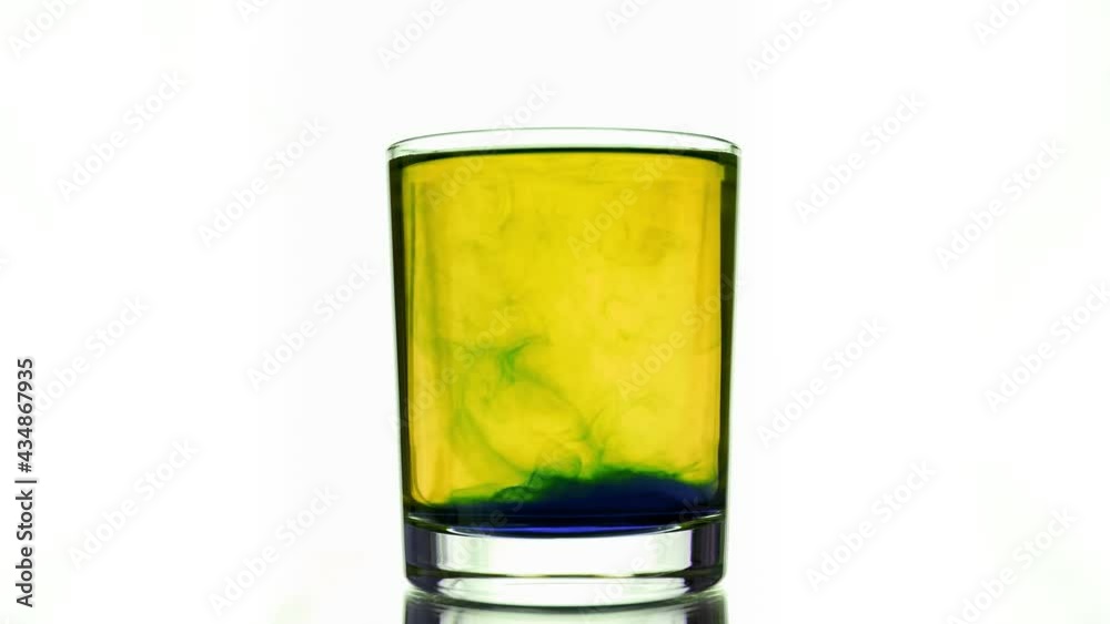 Mixing using glass stick of blue pigment dissolve at yellow colored ...