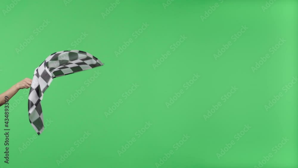Female hand holding and waving checkered race flag in slow motion against green screen ...