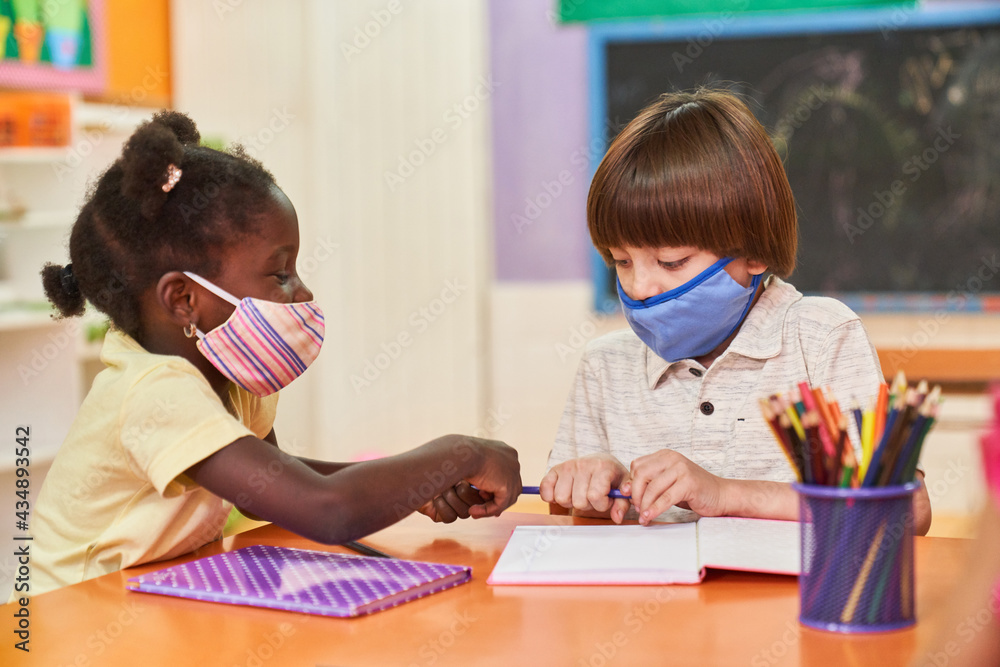 Two children with face masks in elementary school Stock Photo | Adobe Stock