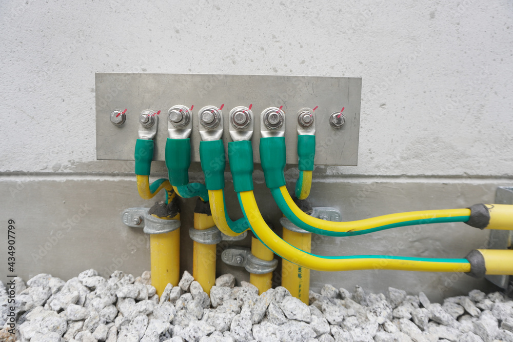Electrical high voltage ground copper bar on wall. Grounding electric bar. Cables connected to ...