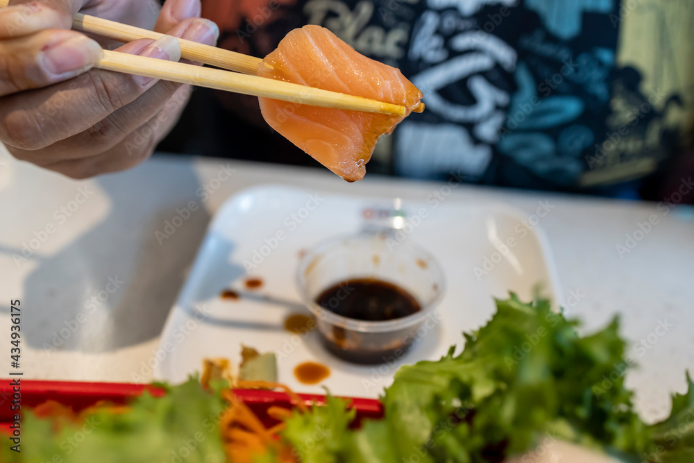 close up view of African American black woman eating sushi at a ...