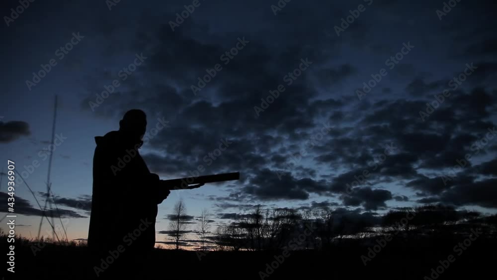 Silhouette of a hunter at night with a gun. Silhouette of a hunter with ...