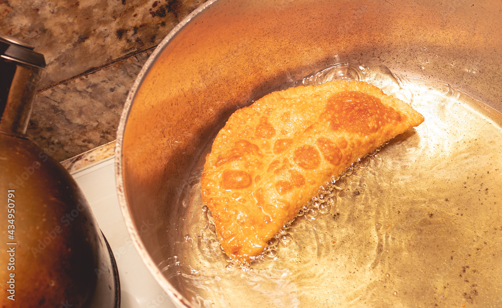 Pastel, Comida brasileira. Um pastel fritando no óleo em uma panela ...