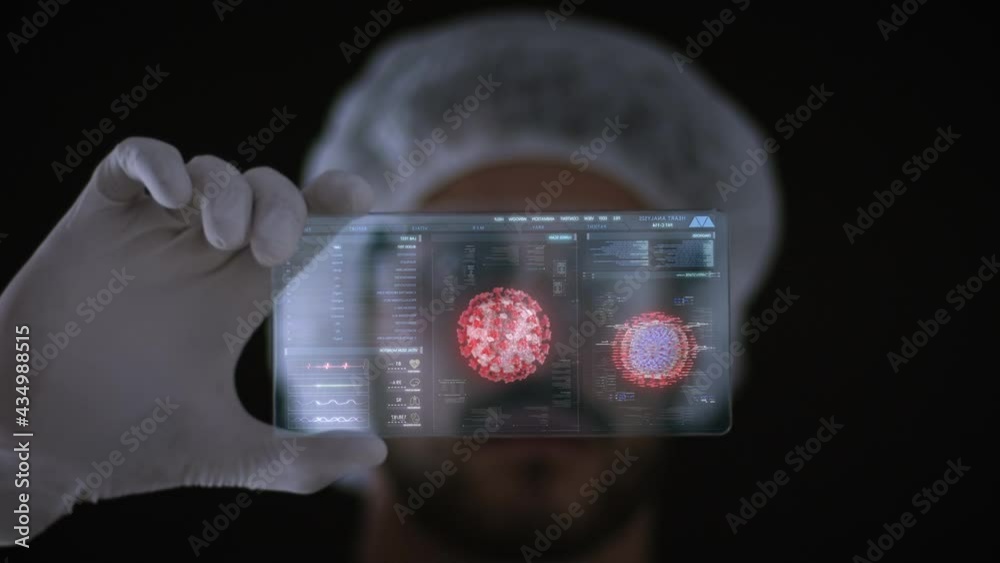 Male Scientist looking at a holographic Coronavirus interface with patient information and Covid ...