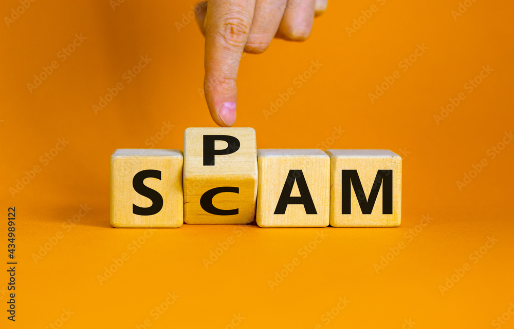 Spam and scam symbol. Businessman turns a wooden cube and changes the ...