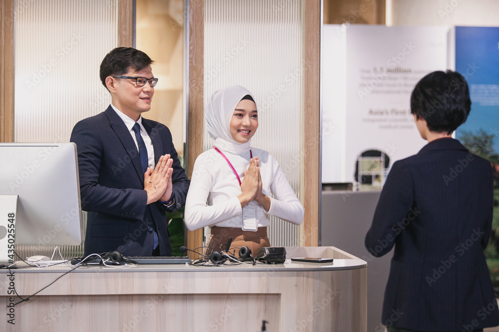 young Asian reception team hotel front desk welcoming . Asian reception ...