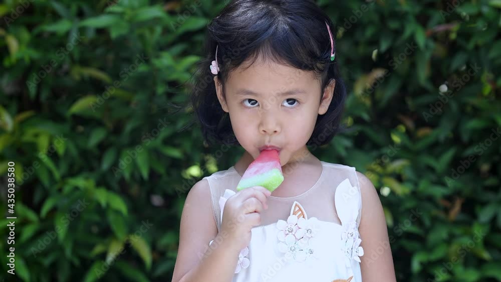 Close up footage of little girl eating ice pop in garden. vídeo de ...