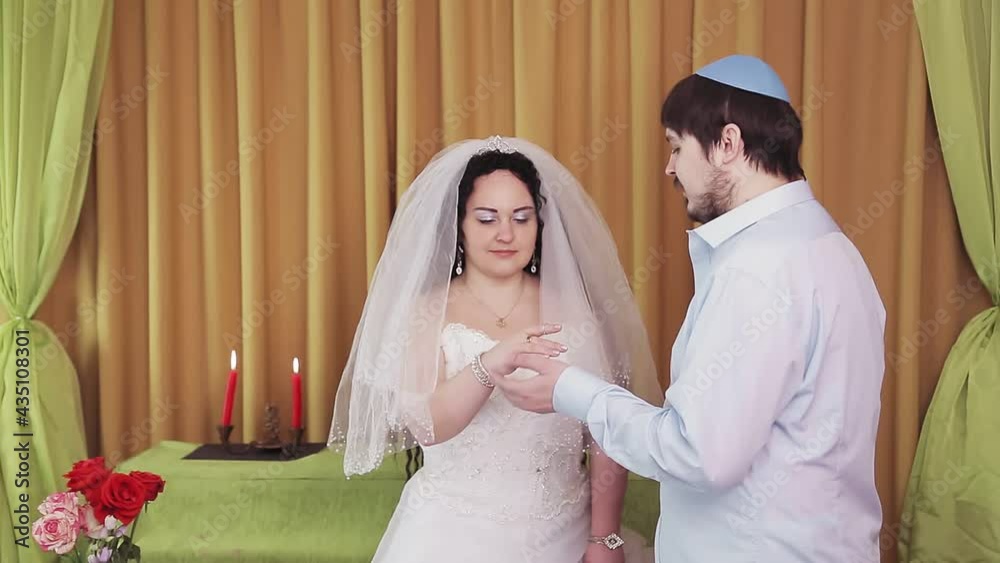 During the chuppah ceremony, a Jewish bride and groom in a synagogue ...