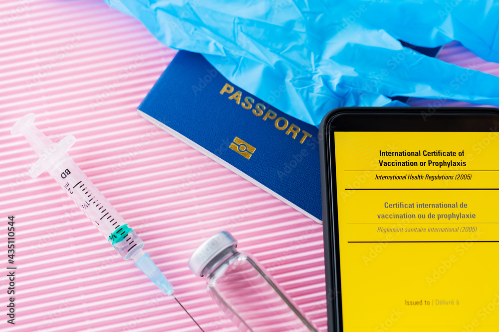 Vaccine bottle, syringe and vaccination passport on a pink background ...