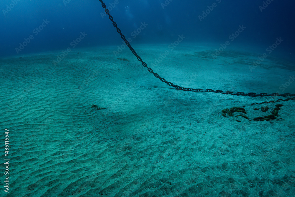 Underwater photo of heavy steel anchor chain that hangs down from water ...